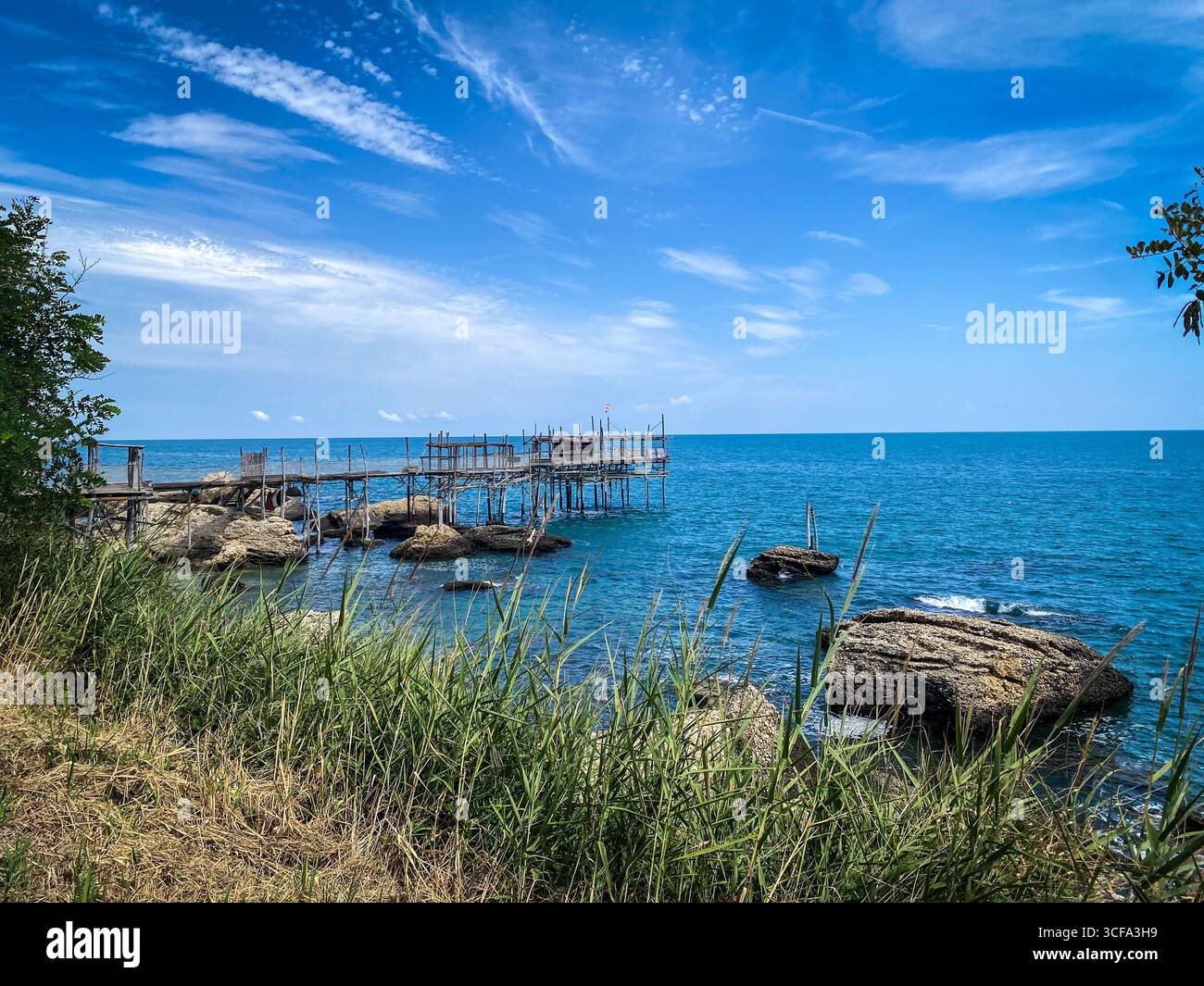 Traditional wooden fishing platform extending over rocky Adriatic ...