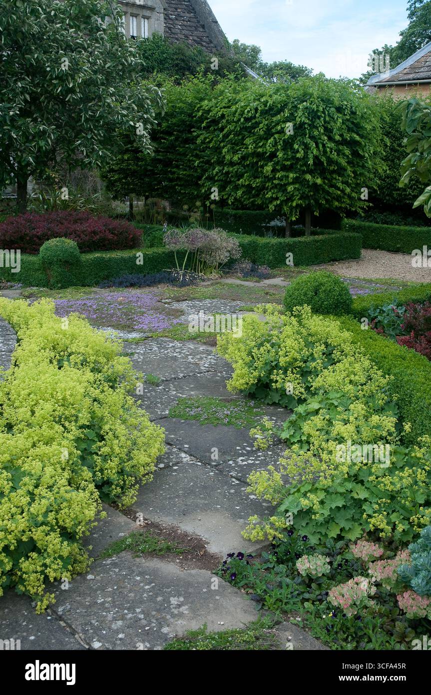 A beautifully landscaped garden pathway lined with vibrant plants and ...
