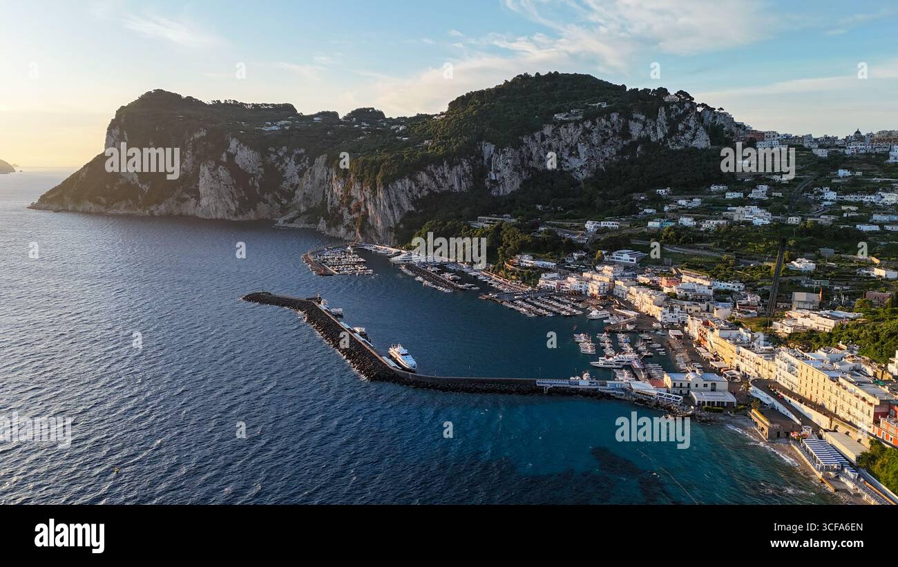 Majestic cliffs embrace the azure waters surrounding Capri, as boats ...