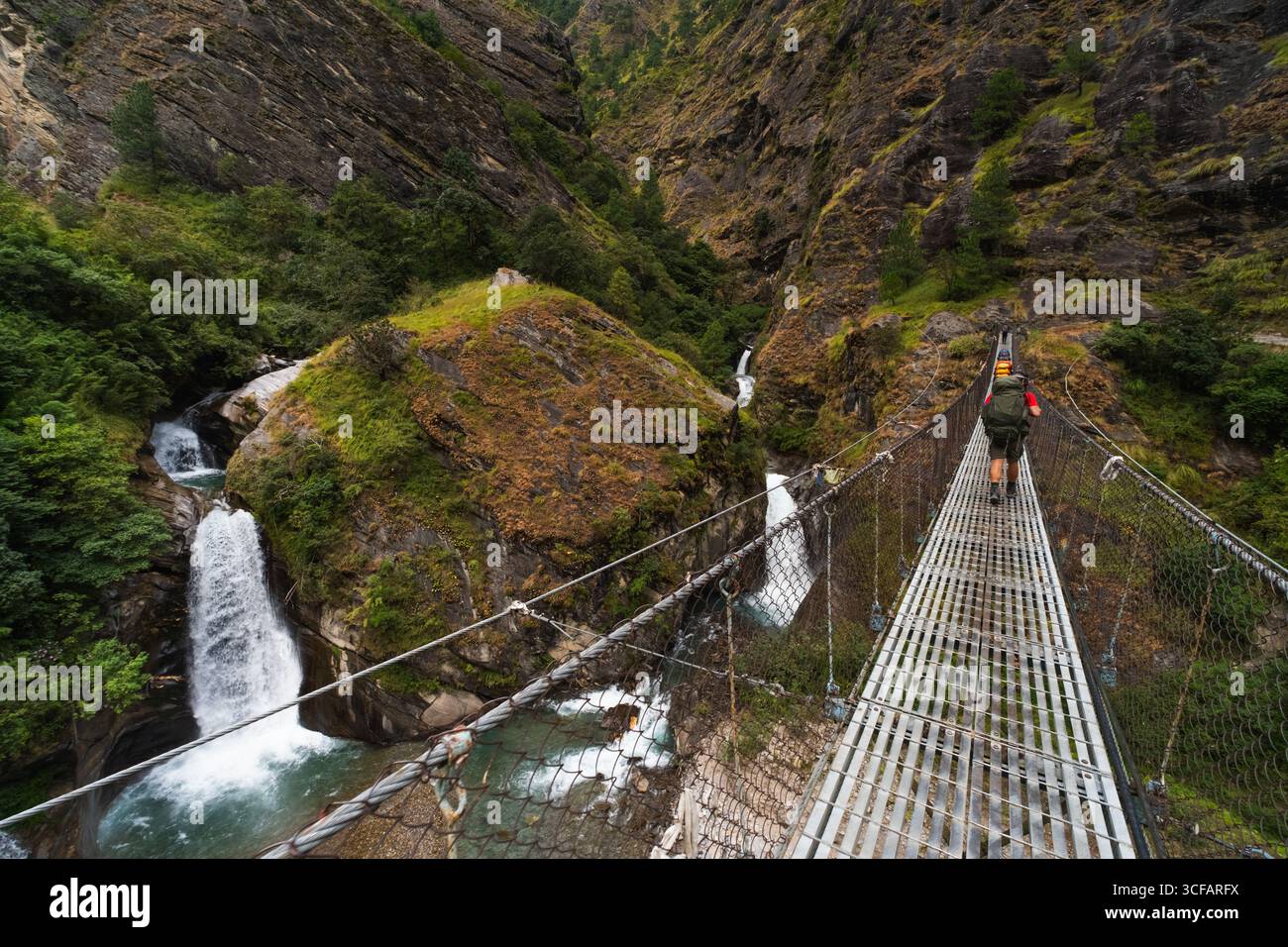 Suspension bridge crossing over river in Himalayan valley, Nepal Stock ...