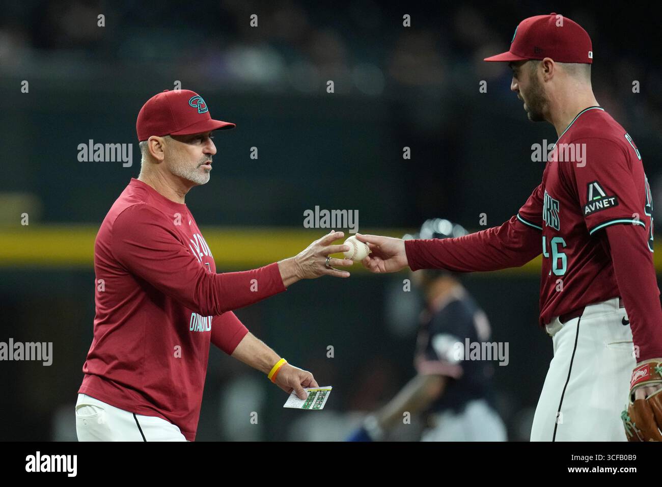 Arizona Diamondbacks manager Torey Lovullo, left, takes the ball from ...