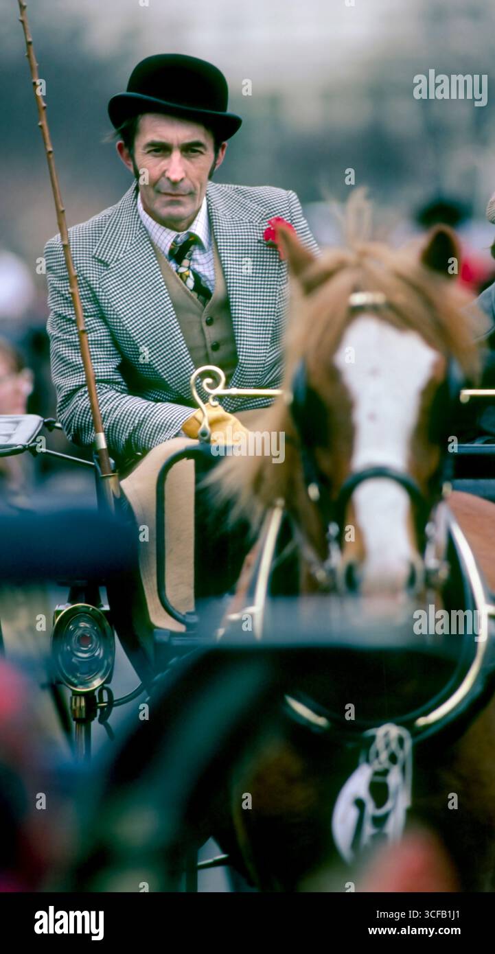 Man wearing a traditional English hat sitting in a buggy during the ...