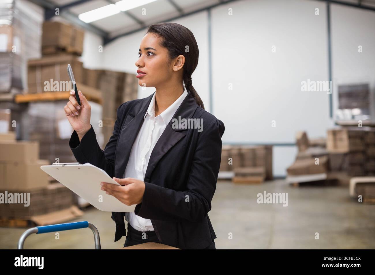 Woman wearing blazer holding clipboard and pen checking boxes on ...