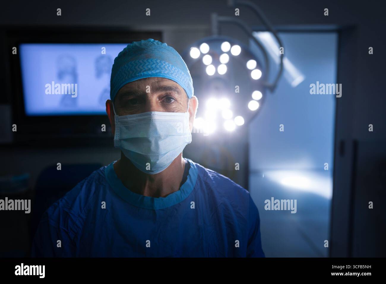Overhead surgical lamp is glowing in operating room while monitor is ...