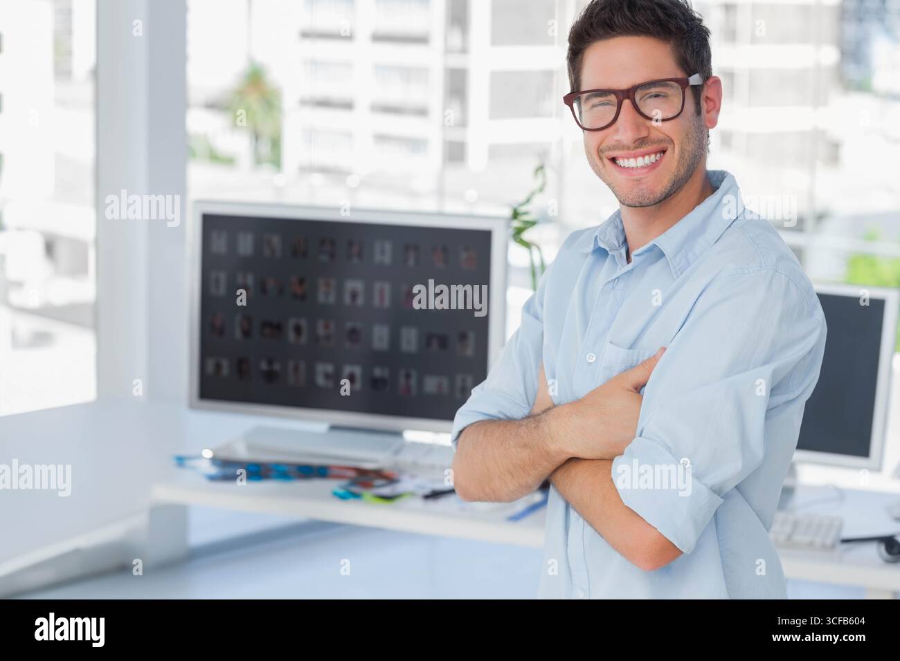 Desk holding dual monitors displaying thumbnails and color swatches ...
