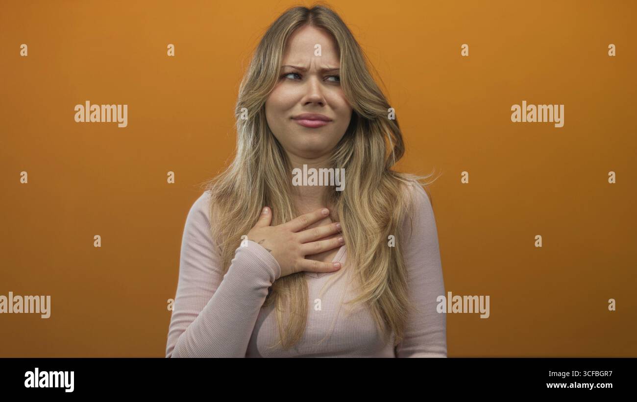 Blonde woman points finger to chest with raised brow and pursed lips in ...