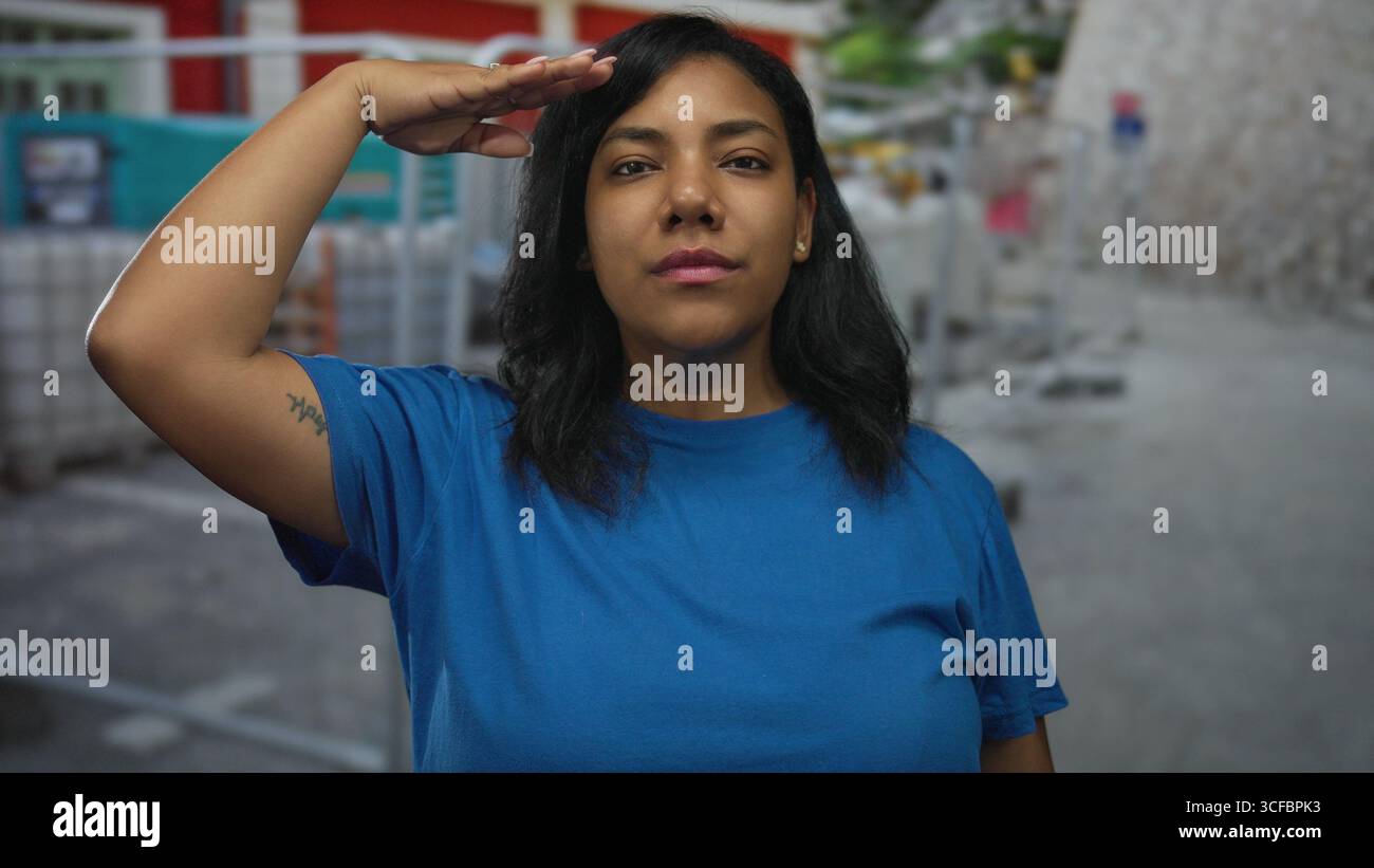 African american woman salutes with her right hand to her forehead in ...