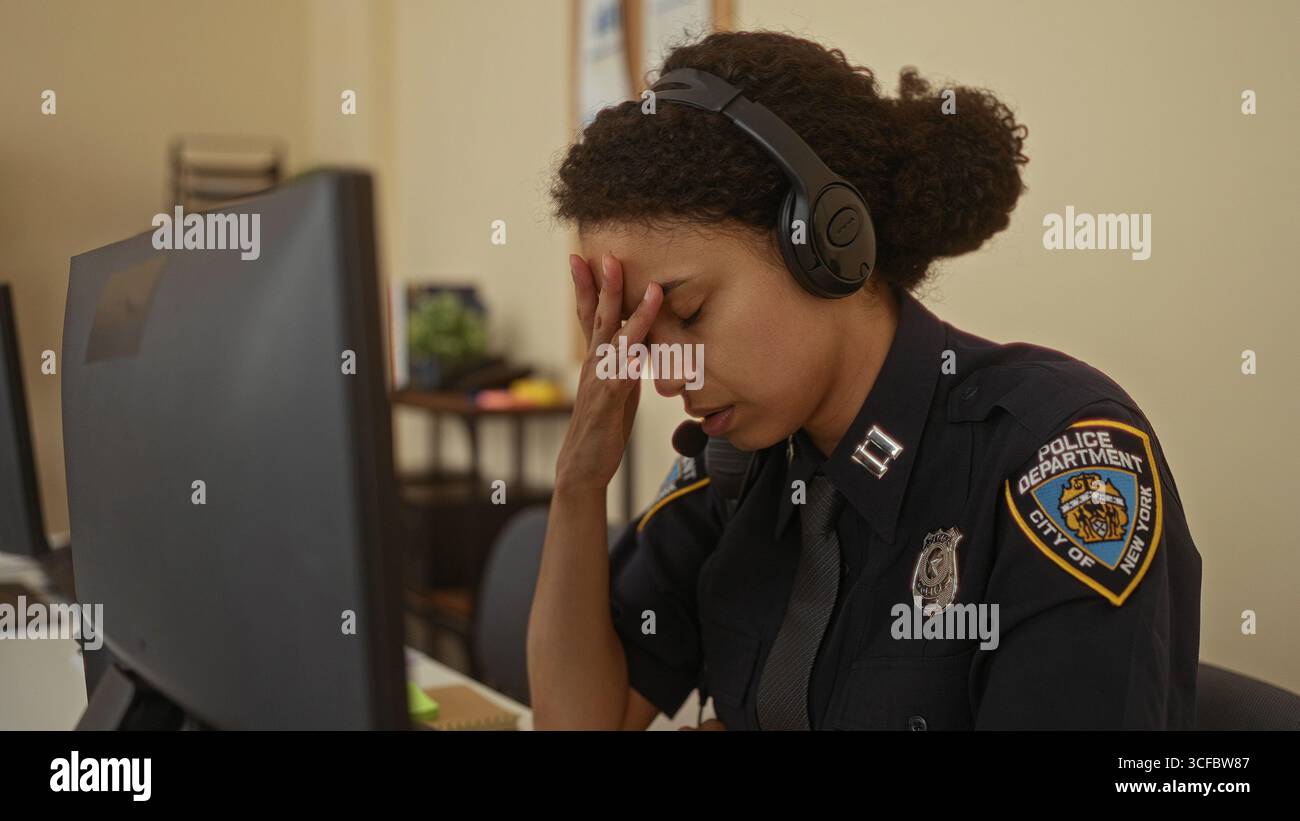 Woman police officer in uniform concentrates at desk with headset in ...