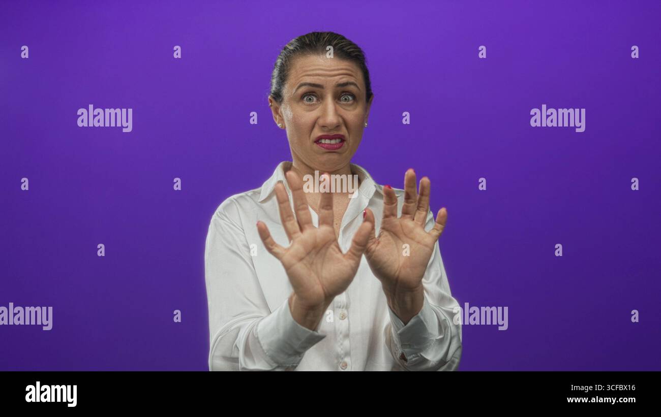Woman grimaces with closed eyes and holds hands forward in refusal ...