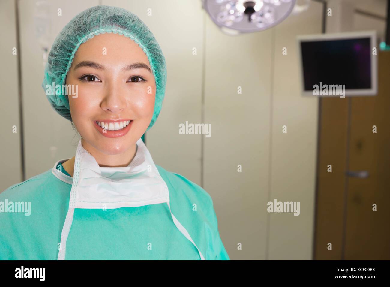 Asian woman surgeon standing in OR wearing surgical scrubs and cap ...