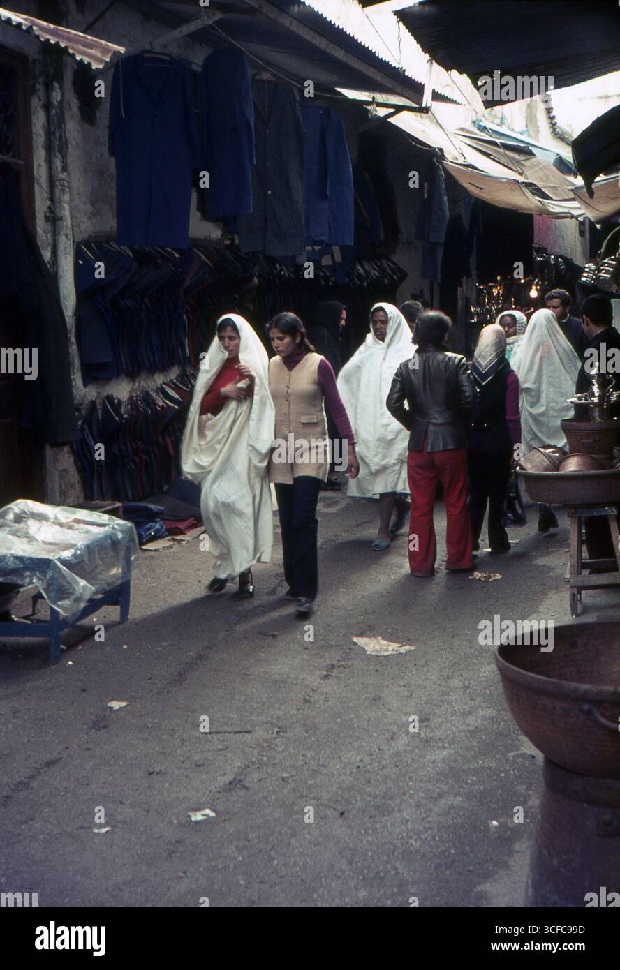 Morocco. 1970s – A souk in Morocco, busy with pedestrians, some wearing ...