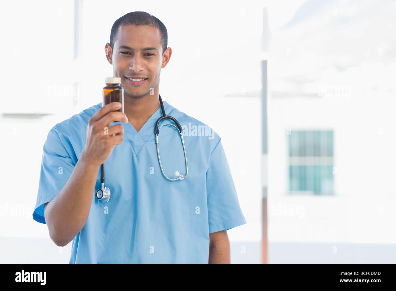 African American male nurse holding pill bottle and checking dose at ...