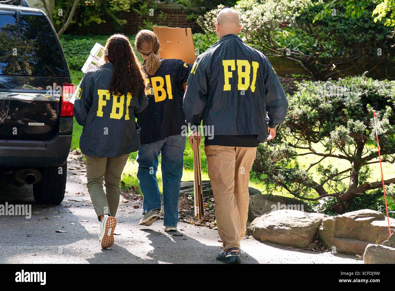 FBI agents carry empty boxes to former national security adviser John ...