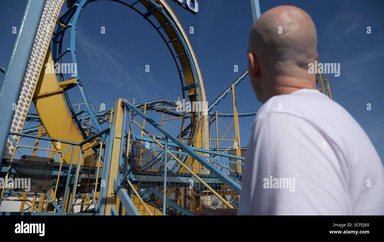 Dean Stokes looking at a roller coaster while on Brighton Pier in East ...