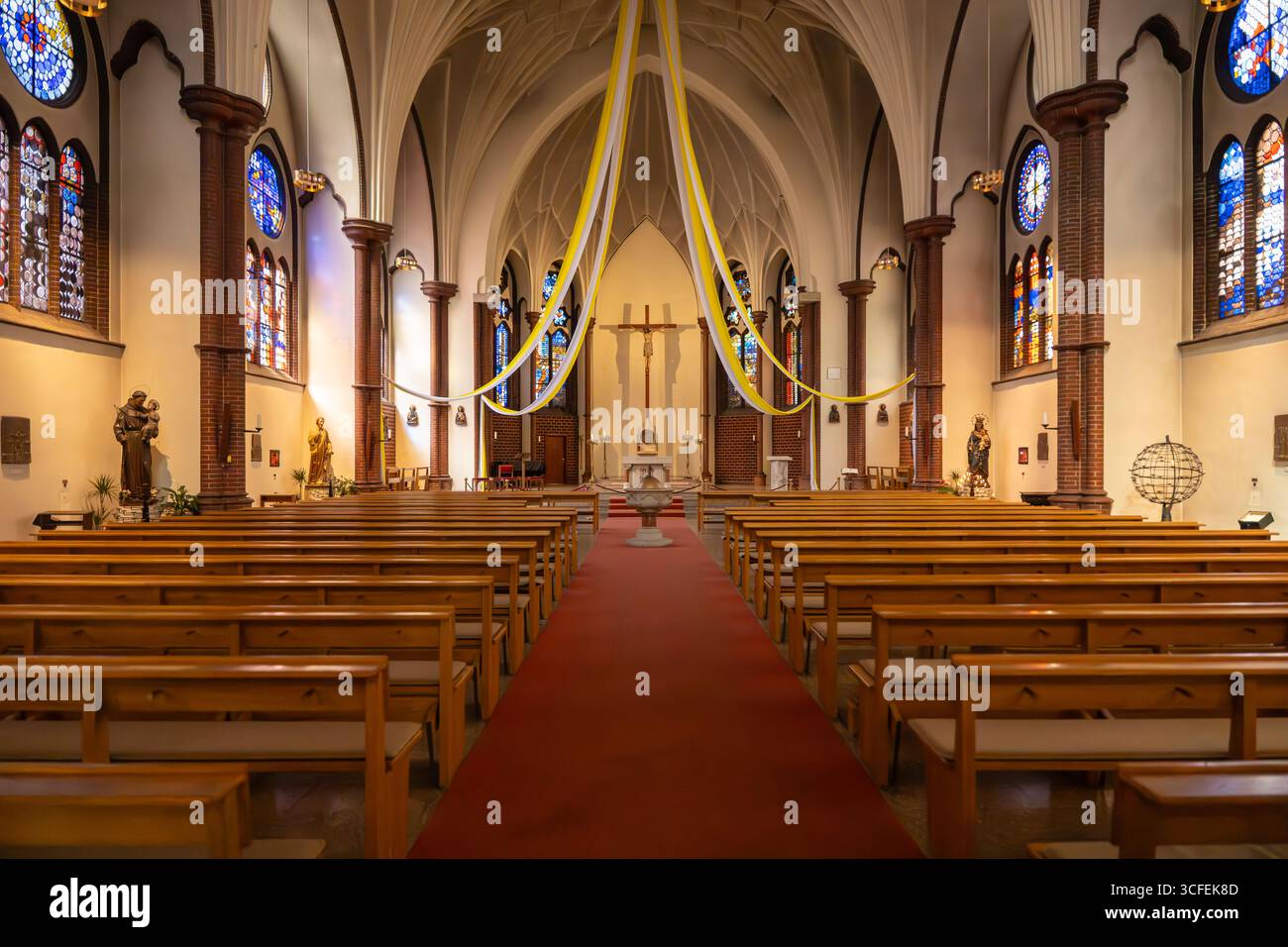 Church interior view towards the altar with ribbons and stained glass ...