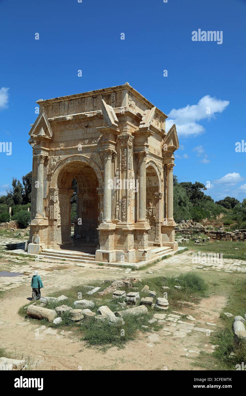 Tourist walking towards the famous Arch of Septimius Severus at Leptis ...