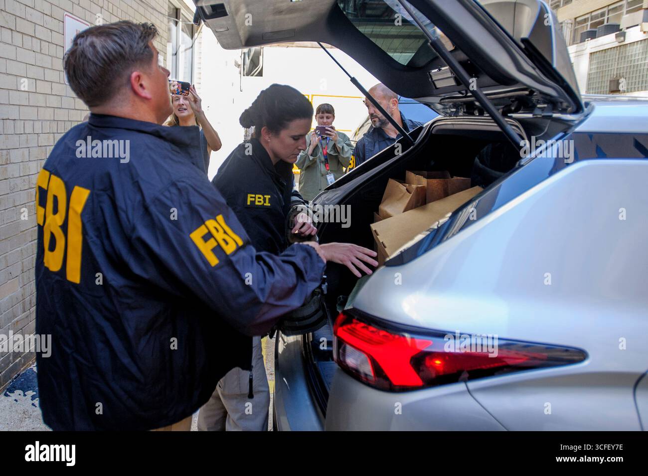FBI agents carry boxes from former National Security Advisor John ...