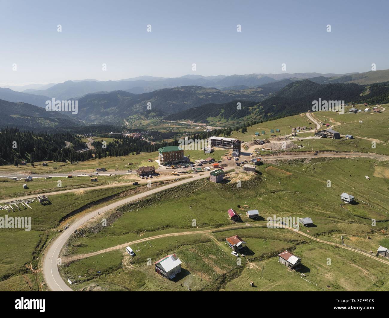 Aerial view of emerald meadows dotted with quaint cottages and a ...