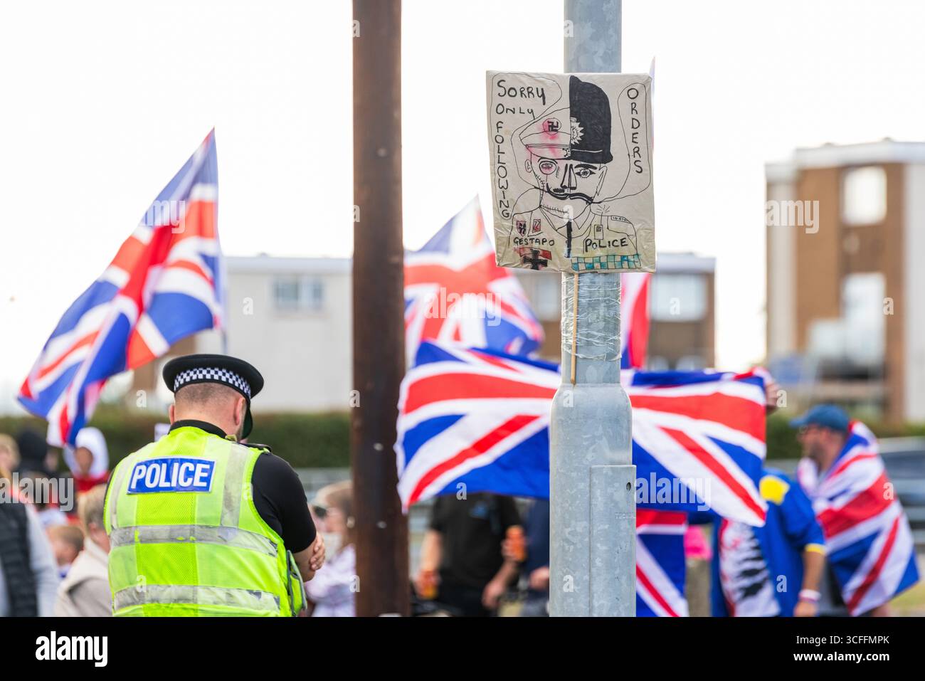 Leeds, UK. 22 AUG, 2025. Police/Gestapo sign as anti-migrant protestors ...