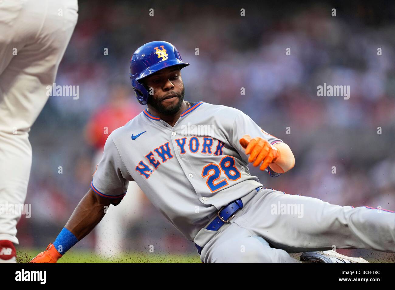 New York Mets' Cedric Mullins (28) slides into third base after hitting ...