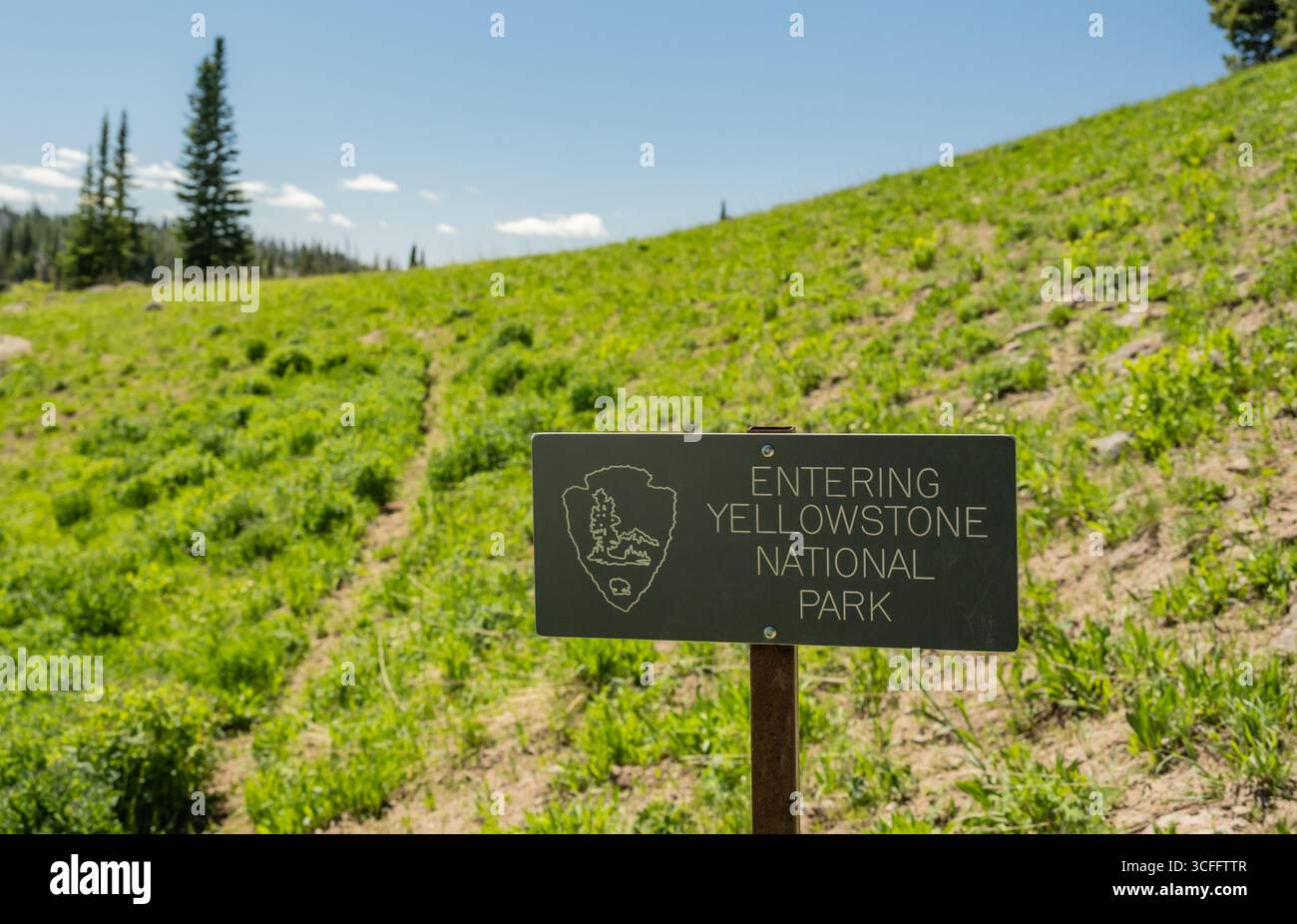 Faint Trail Curves Past Entrance Sign To Yellowstone on park boundary ...