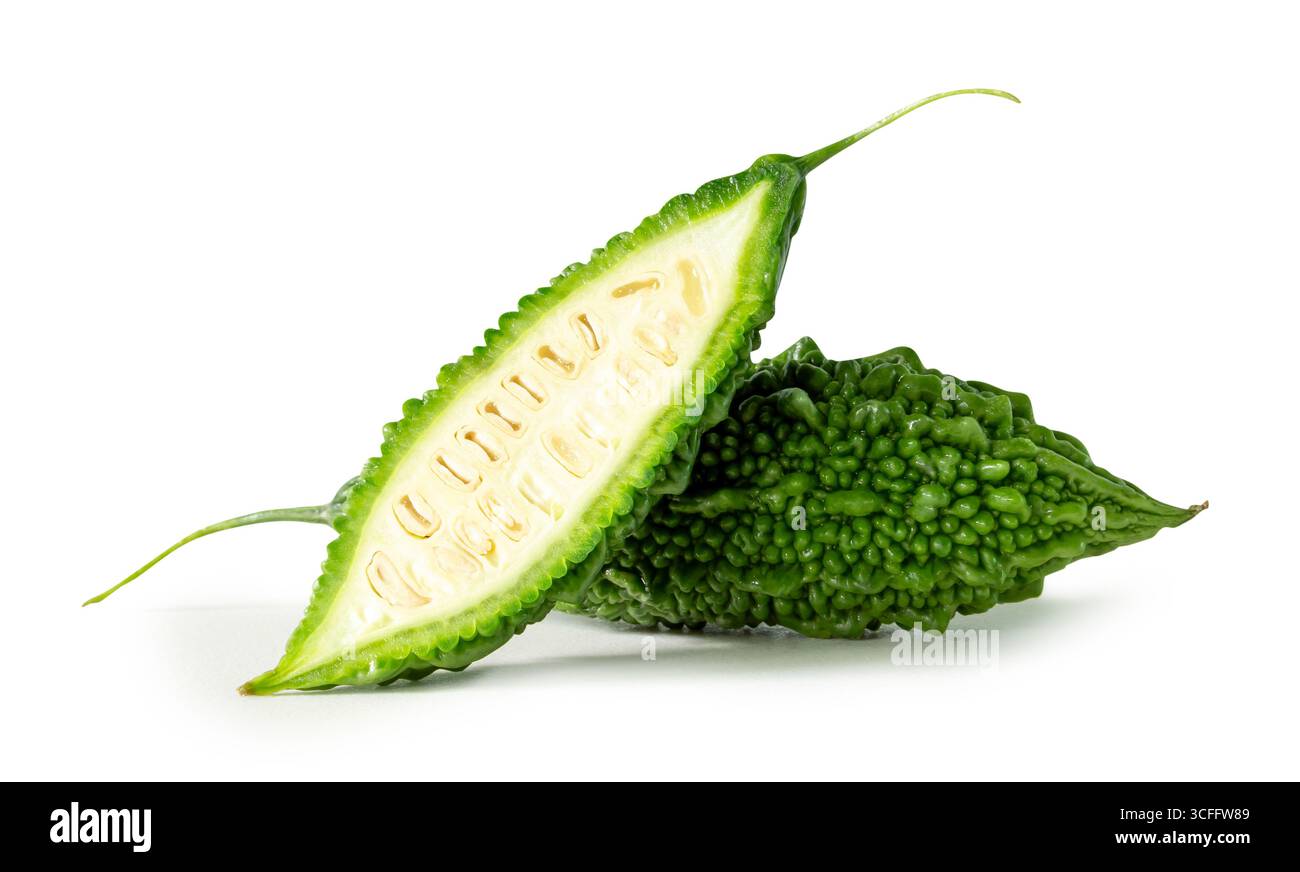 One green bitter gourd or bitter melon with half in stack is isolated ...