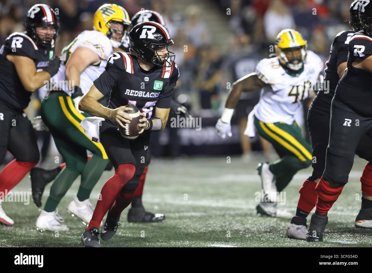 August 22, 2025: Ottawa Redblacks quarterback Dustin Crum (18) escapes ...