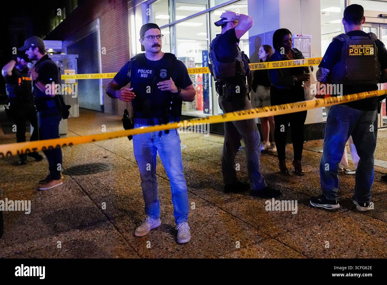 FBI agents, HSI police officers, and DEA agents stand behind a police ...