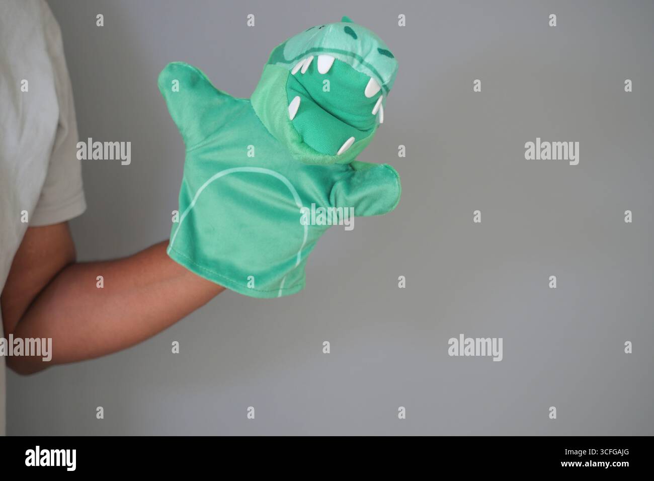Fun green dinosaur puppet in playful hand performance Stock Photo - Alamy