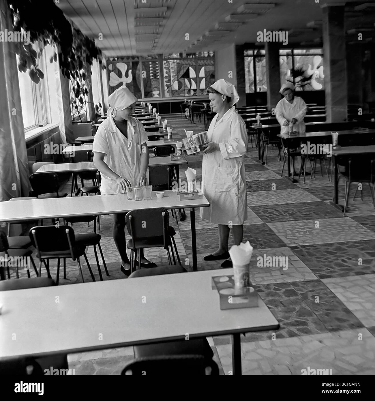 Soviet canteen workers in uniform prepare the dining hall for lunch in ...