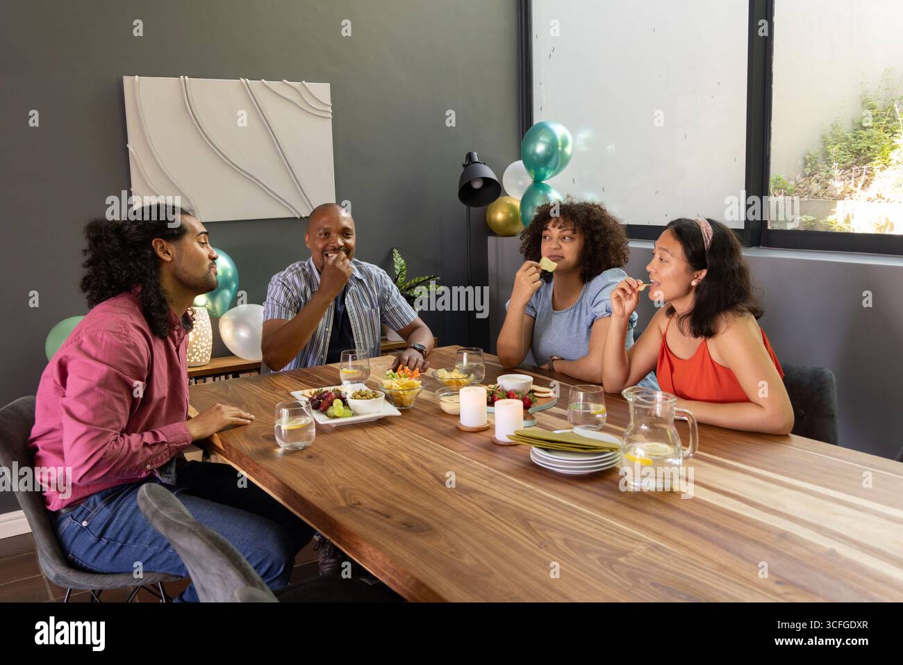 Diverse friends gathering in modern dining room around table sharing ...