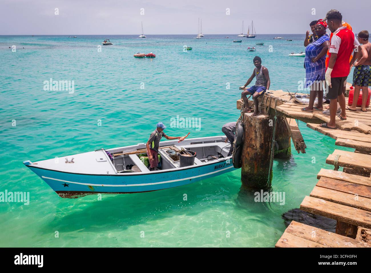 Local fishermen unloading fish from small boats and preparing the catch ...