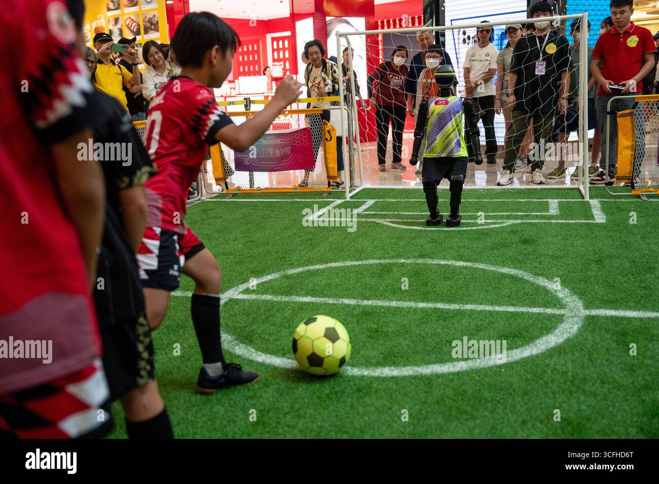 Hong Kong AI Robot Event Kids and robots playing a soccer game at an AI ...
