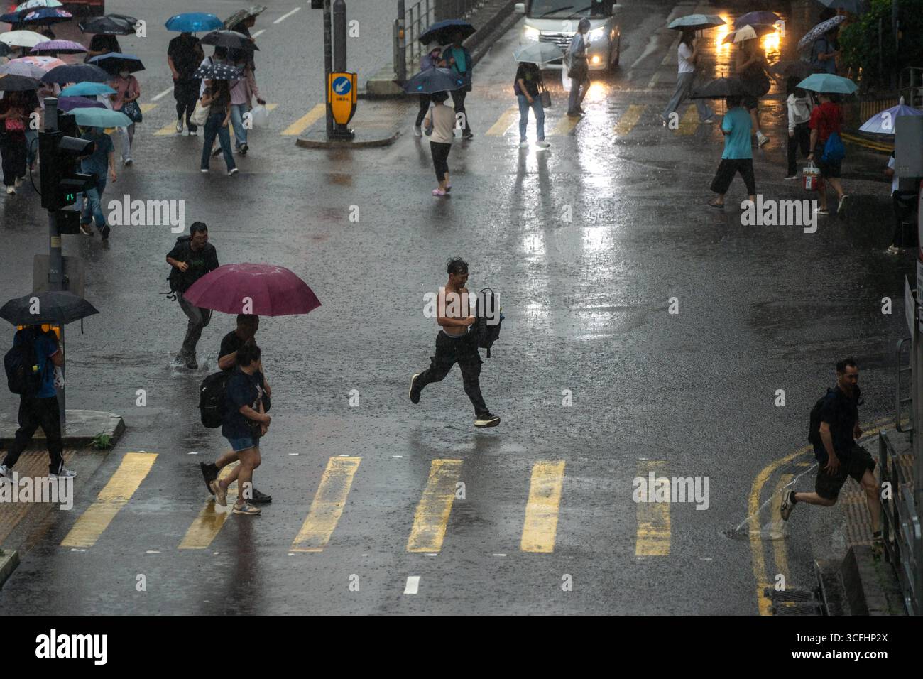 Hong Kong Observatory issues Amber Rainstorm Warning People holding ...