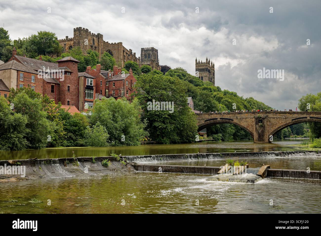The River Wear flows over a weir with Framwellgate Bridge, Castle and ...