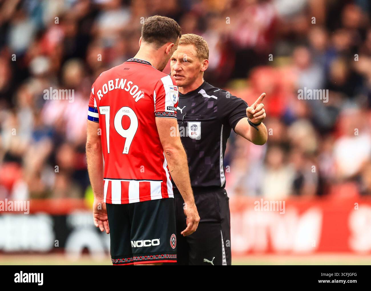 referee John Busby talks to Jack Robinson of Sheffield United during ...