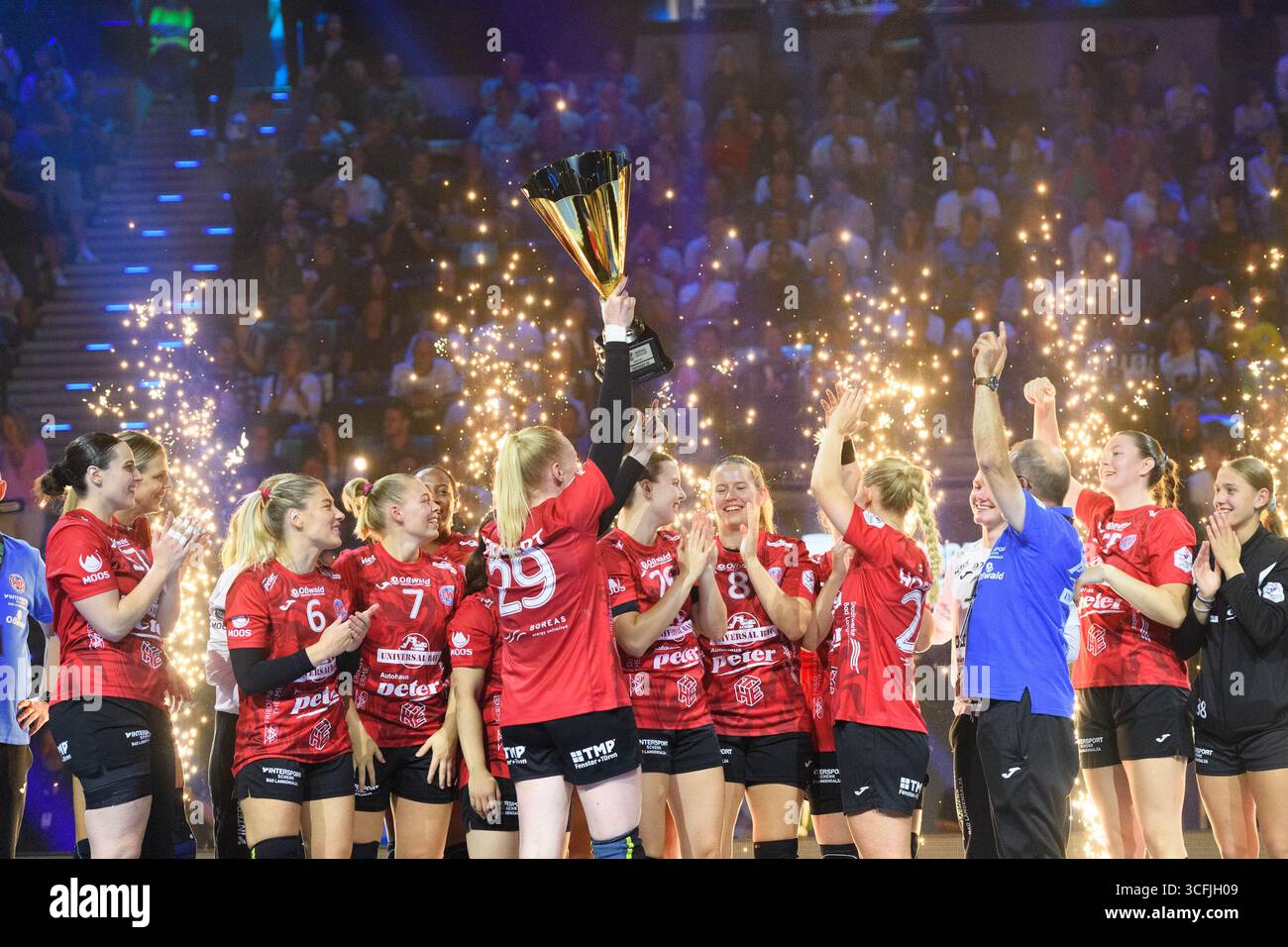Players and staff of Thüringer HC celebrating with the supercup trophy ...