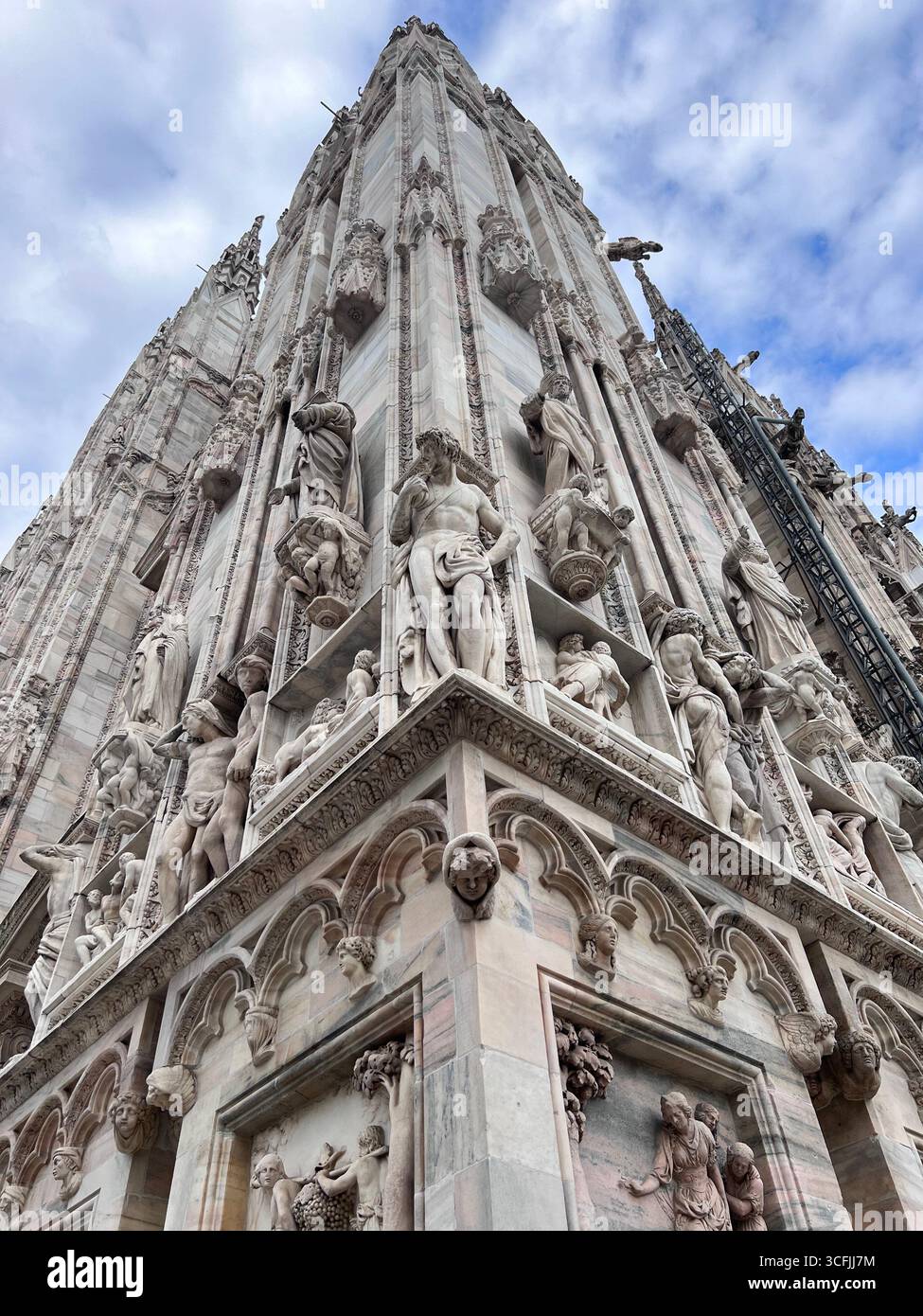 Close-up of Gothic carvings and statues on the marble facade of Milan ...