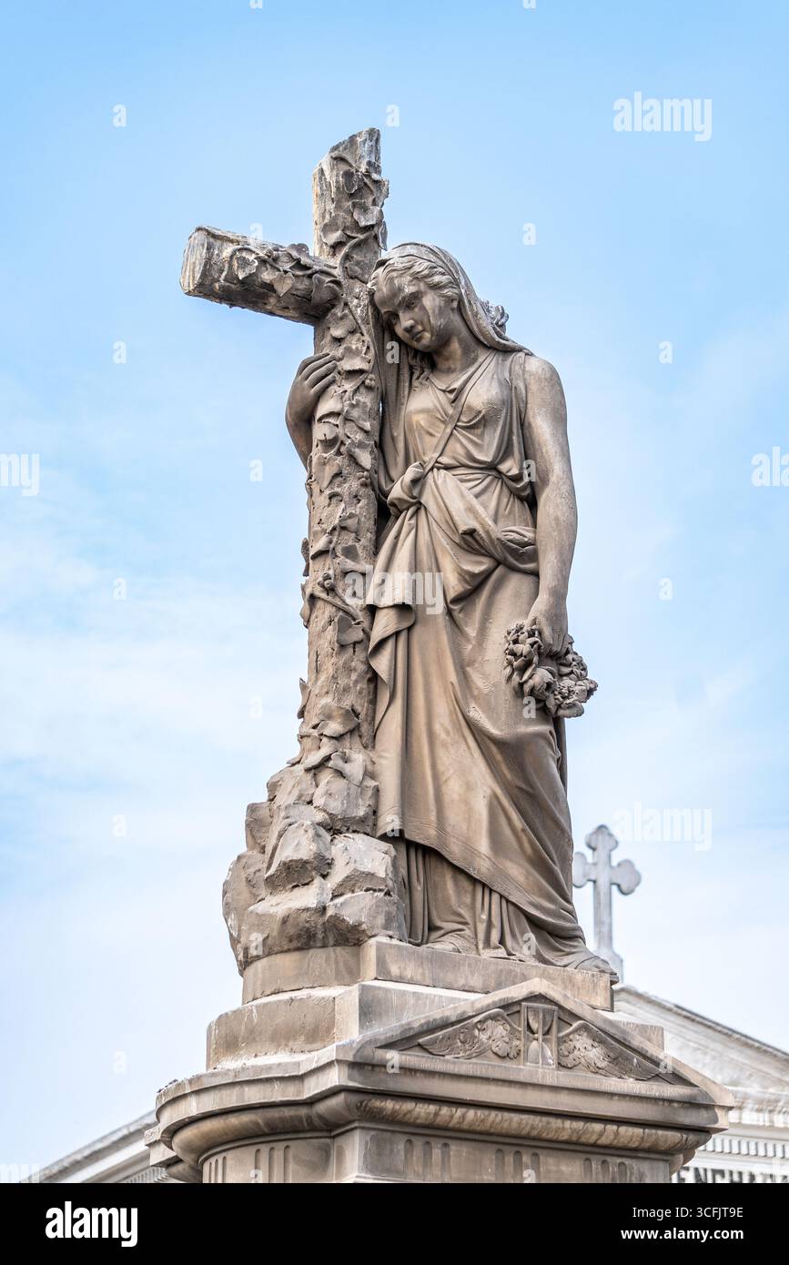 Funerary female statue leaning on stone cross atop ornate pedestal at ...