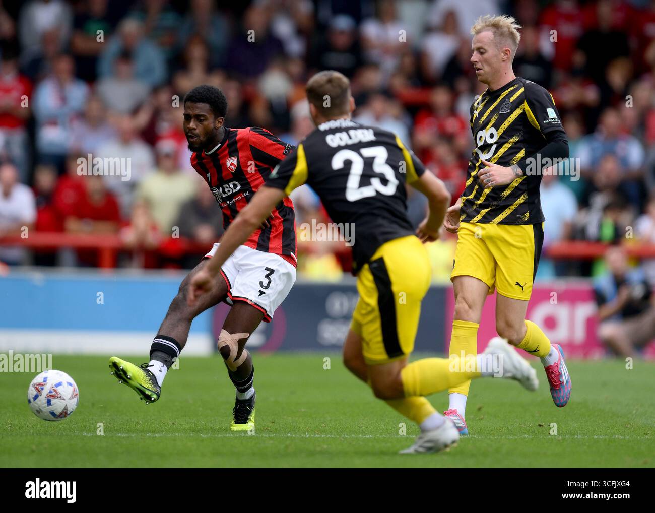 Morecambe's Raheem Conte (left) passes the ball past Altrincham's Tyler ...