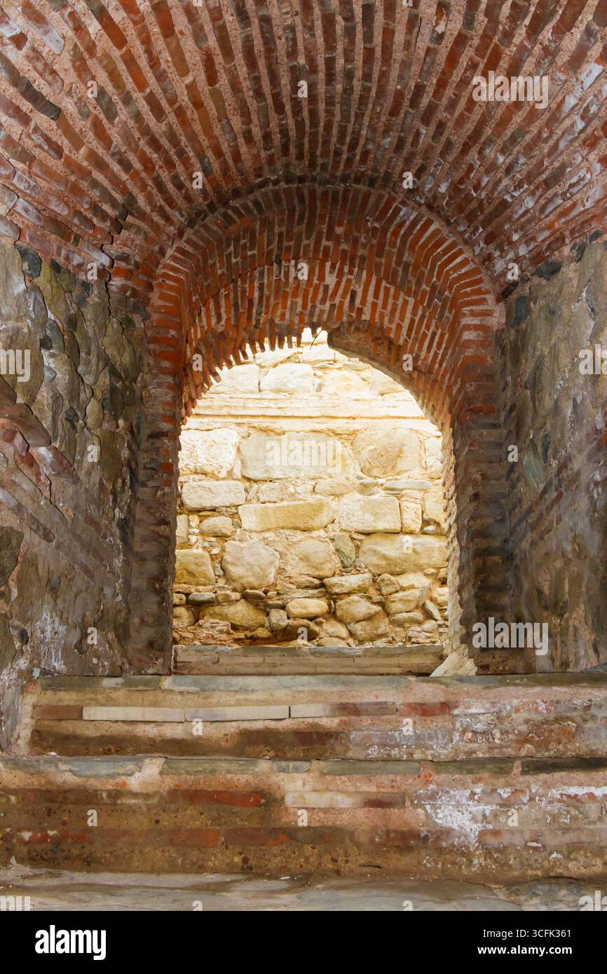 A well-preserved brick archway frames a view of worn stone steps ...