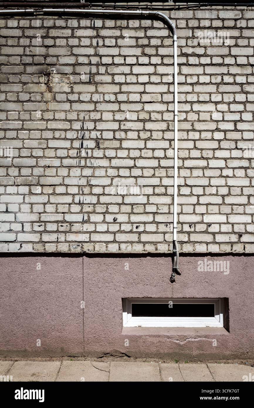 White brick wall with some cables and basement window. Architectural ...