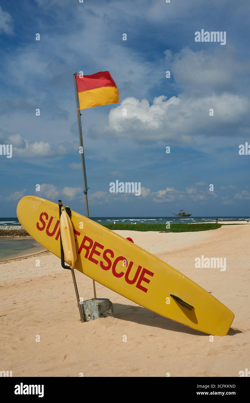 Surf rescue boards and red and yellow warning flags on a sandy beach in ...