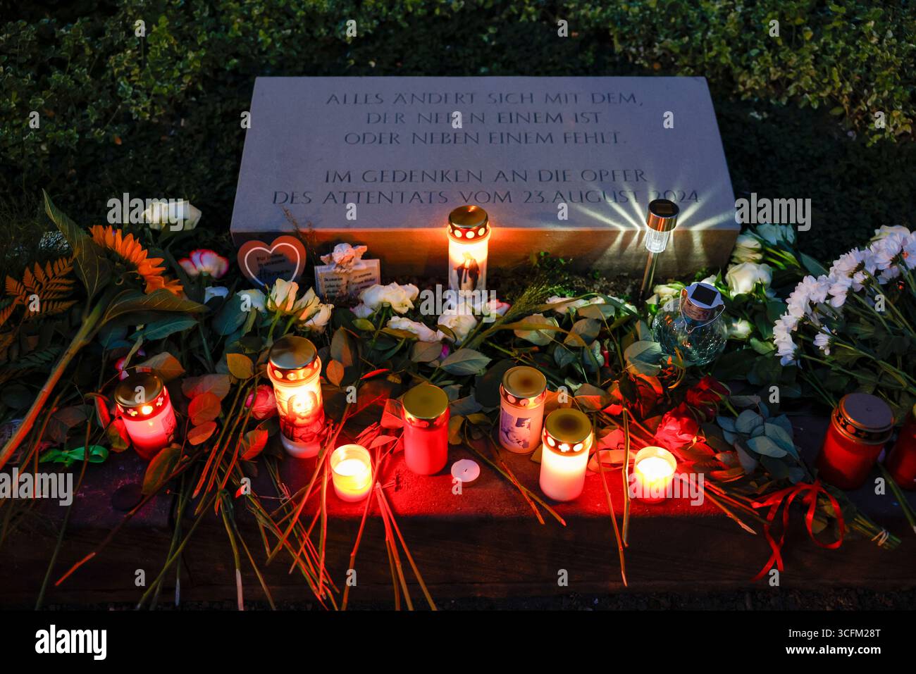 23 August 2025, North Rhine-Westphalia, Solingen: Flowers and candles ...