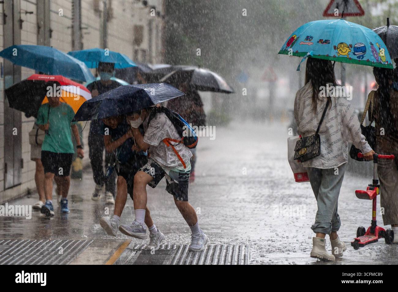 Hong Kong Observatory issues Amber Rainstorm Warning People holding ...