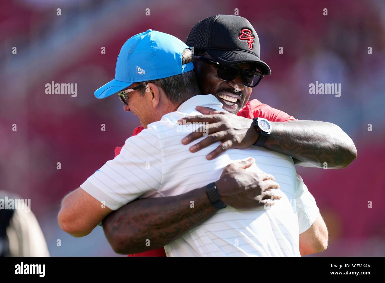 Los Angeles Chargers head coach Jim Harbaugh, left, hugs ormer San ...