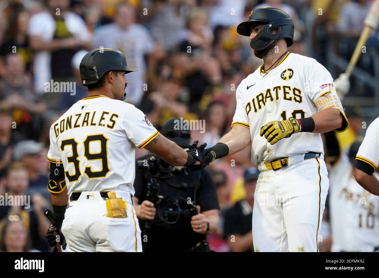Pittsburgh Pirates' Jared Triolo, right, is greeted by Nick Gonzales ...