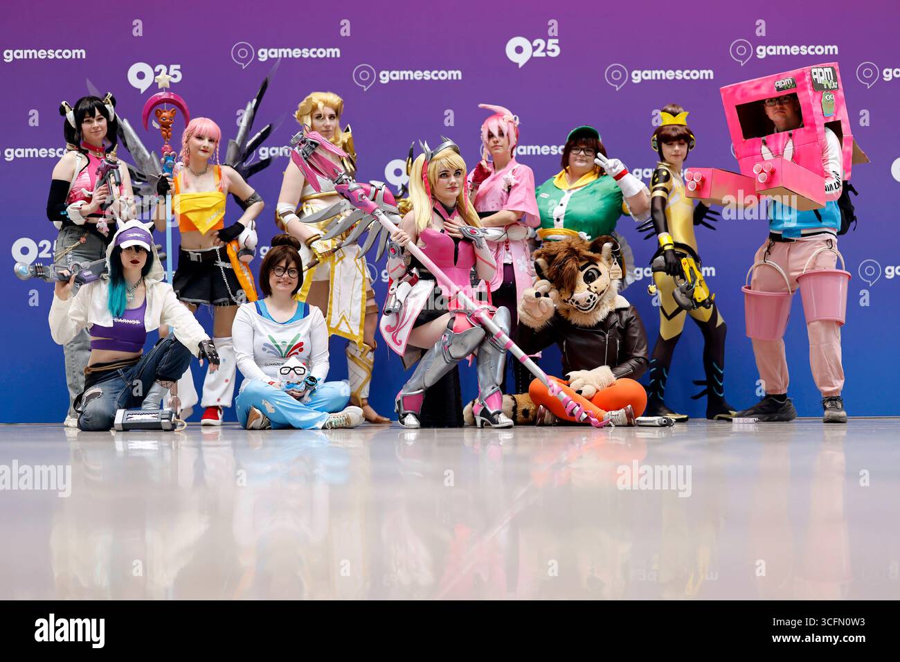 Cosplayer in verschiedenen Kostümen posieren vor dem Gamescom-Logo auf ...