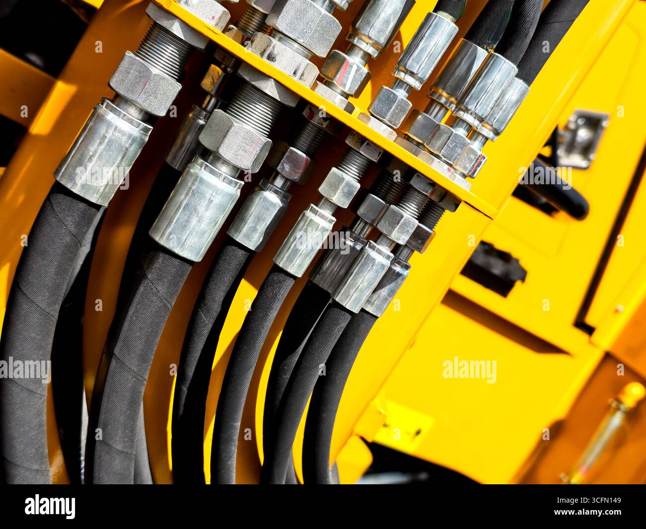 Hydraulic hoses connect within heavy machinery during maintenance work ...