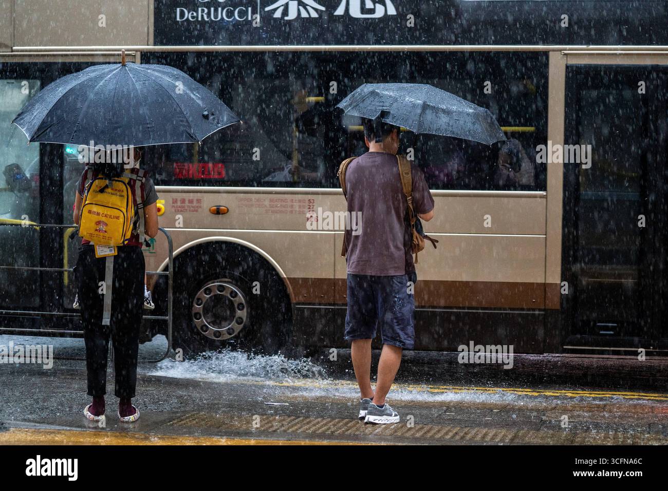 Hong Kong Observatory issues Amber Rainstorm Warning People holding ...